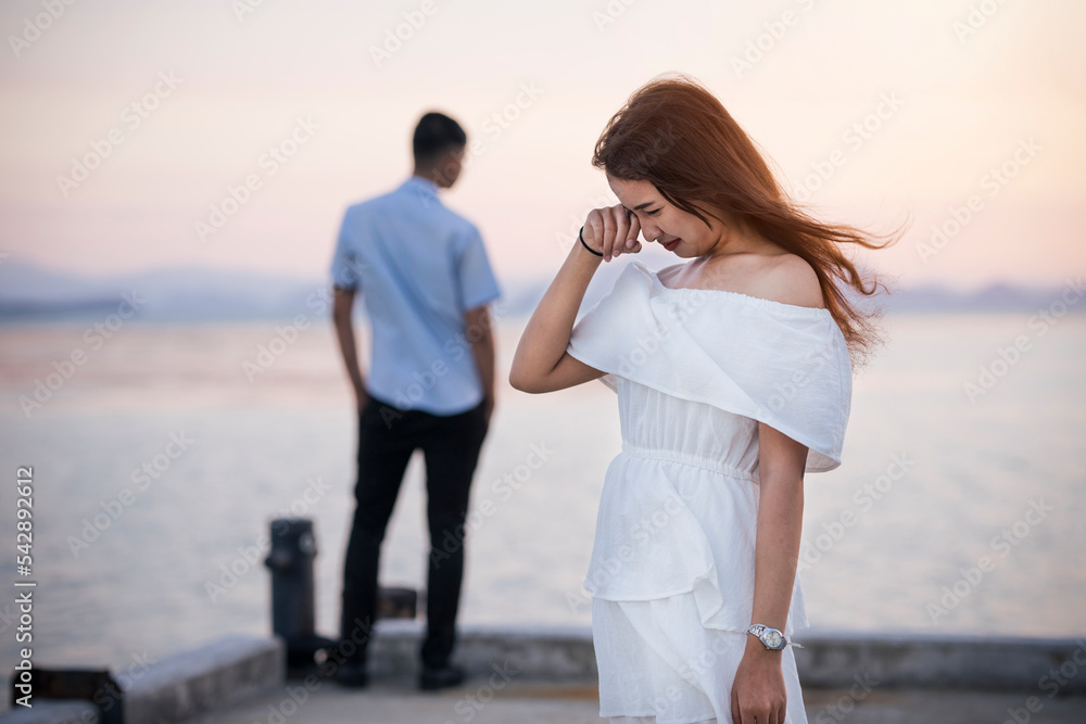 Foto de Young couple break up at the sea deck. Girl crying and walk ...