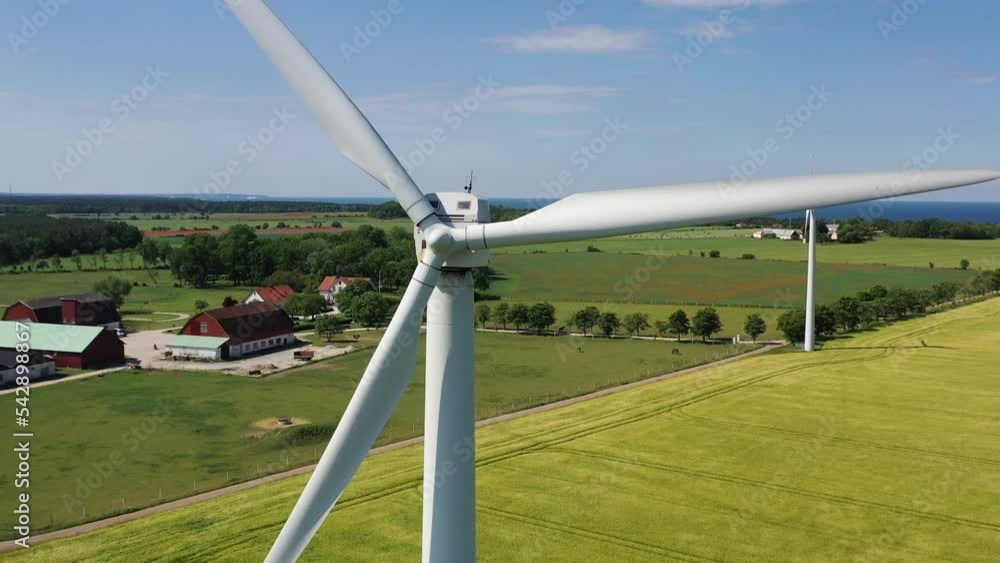High tech wind power turbine in vibrant farmland, aerial close up view ...