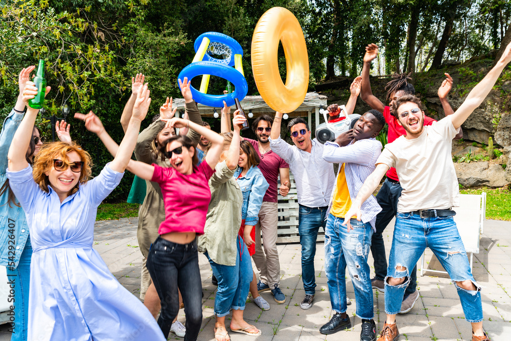 Multicultural friends group having fun out side cheering with boombox ...