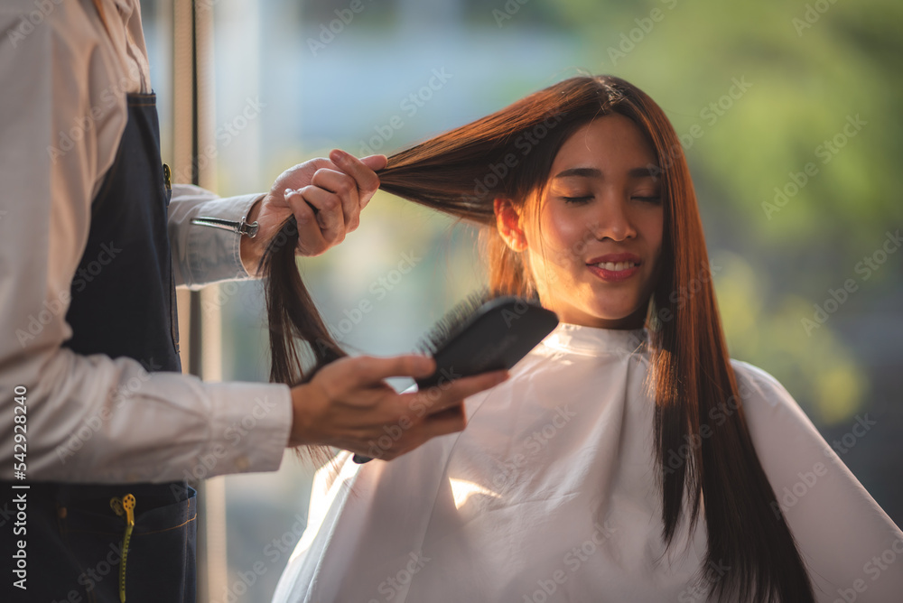 Young beautiful and smiling Asian woman sitting in salon chair against ...