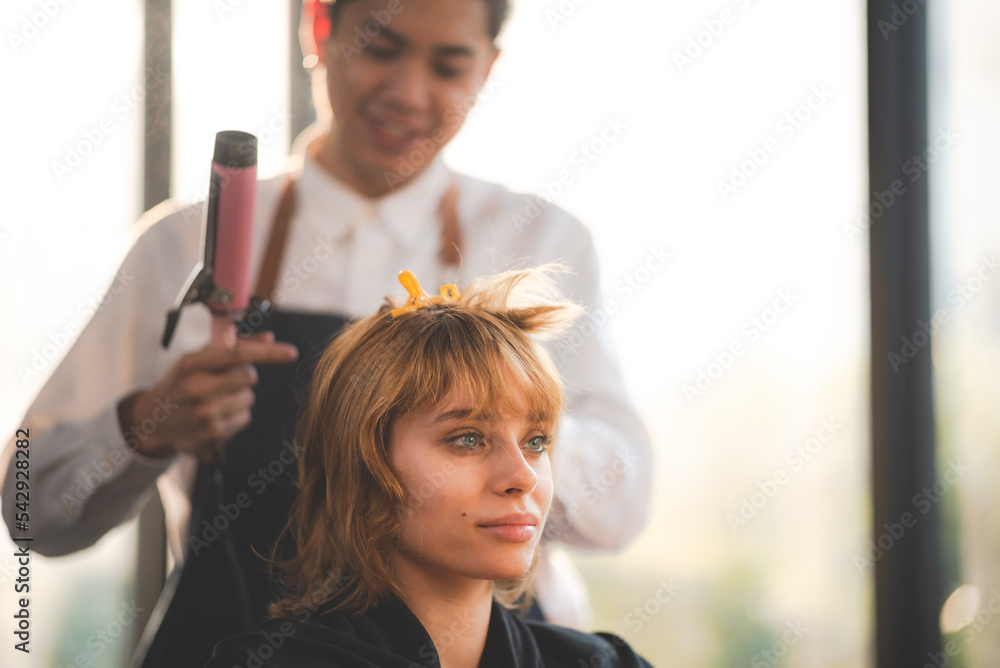 Young beautiful and smiling Asian woman sitting in salon chair against ...