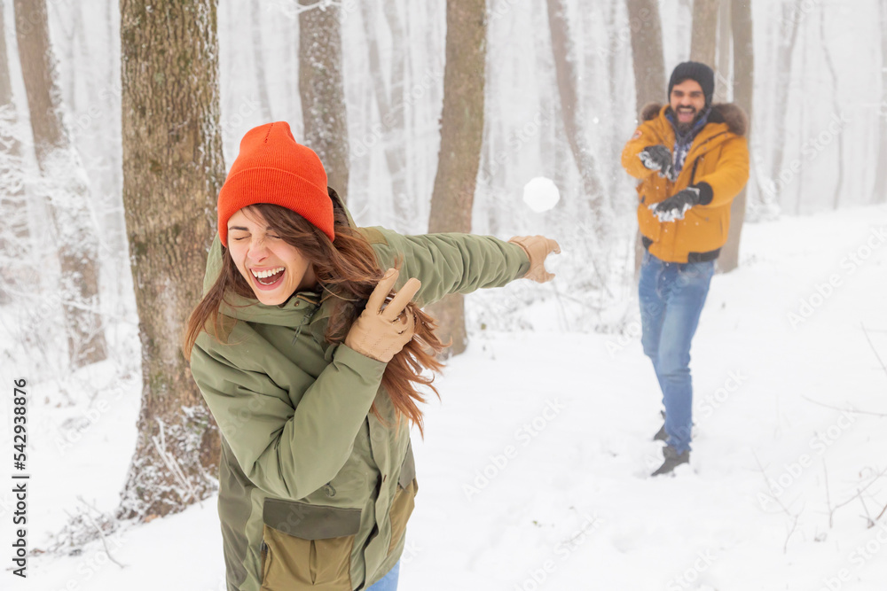 Couple having a snowball fight while on winter vacation Stock Photo ...