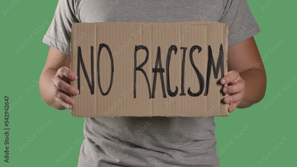 Man holds in front of him a poster from a cardboard box with the words ...
