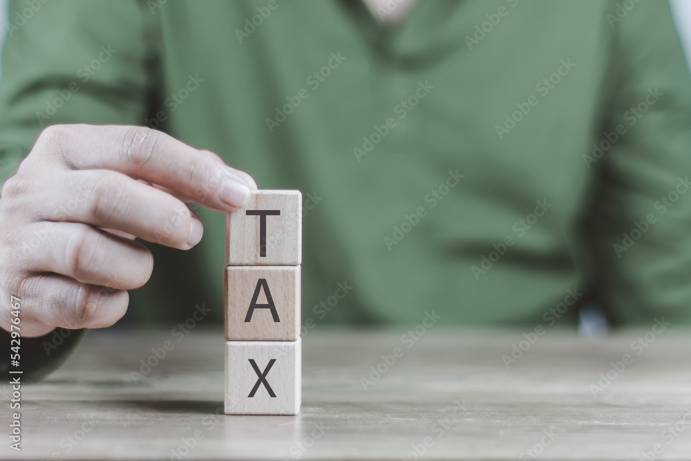 e-tax Invoice conceptman's hand is building a cube wood including debit ...