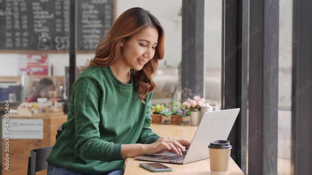 Asian girl working at a coffee shop with laptop connected to the ...