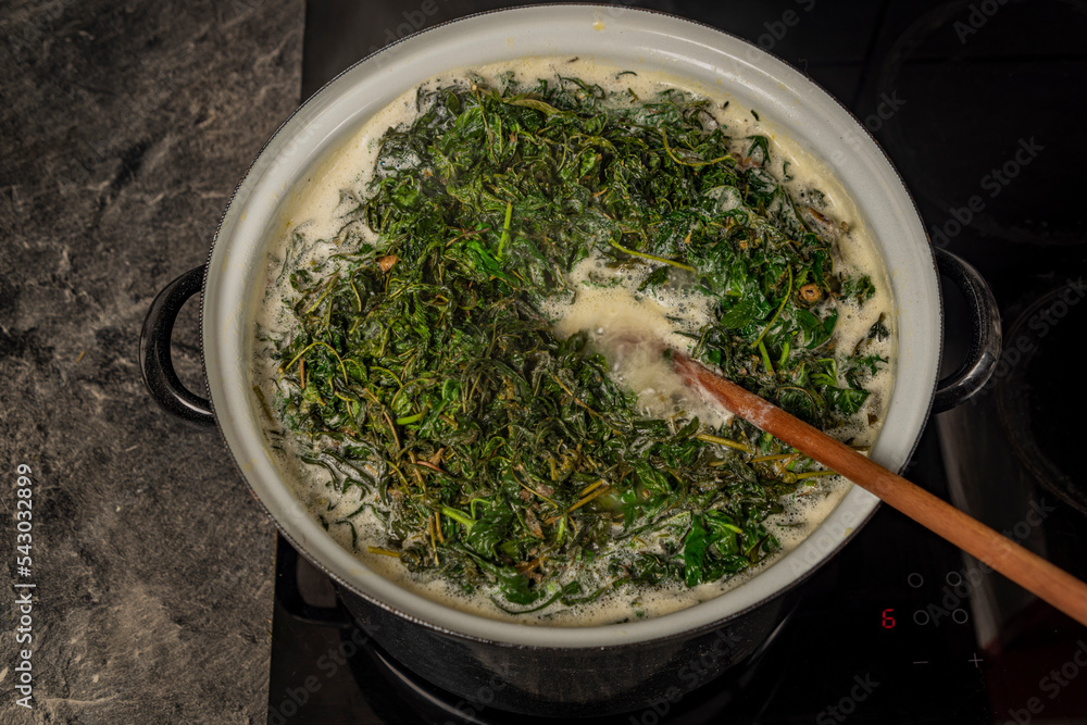 Cooking of marijuana butter in hot water on electric cooker in kitchen ...