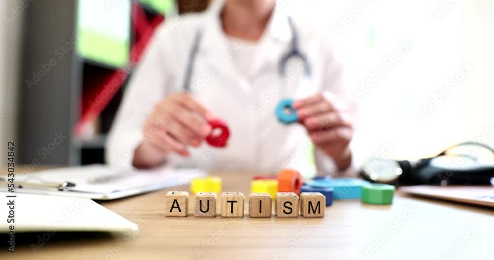 Doctor holds in hands multicolored cubes and text autism Stock Video ...