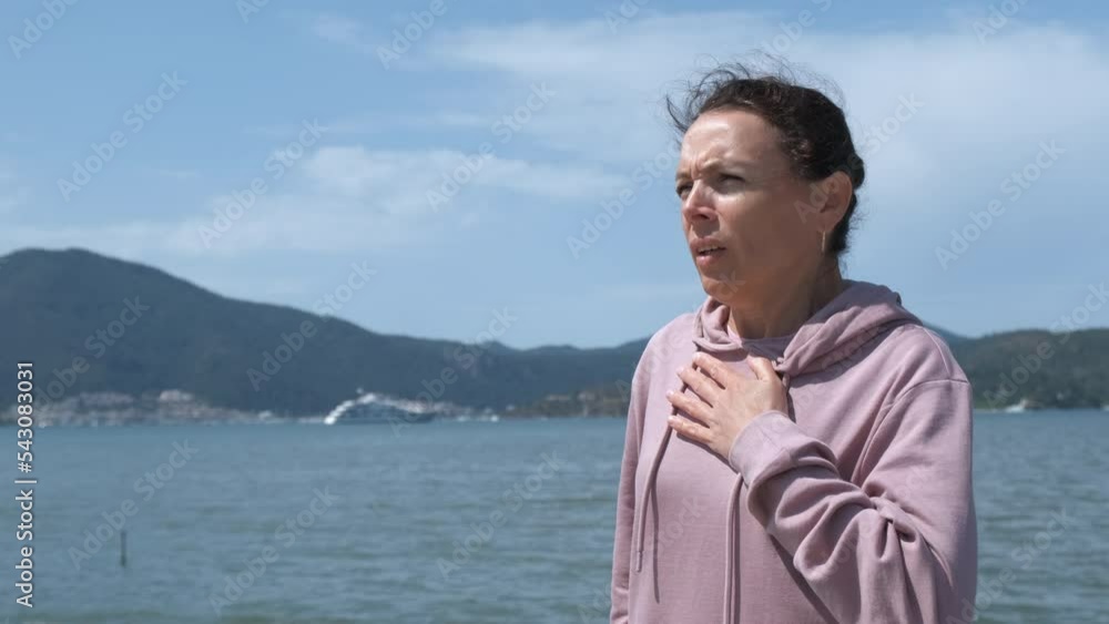 Breathe with an inhaler in nature. The woman has difficulty breathing ...
