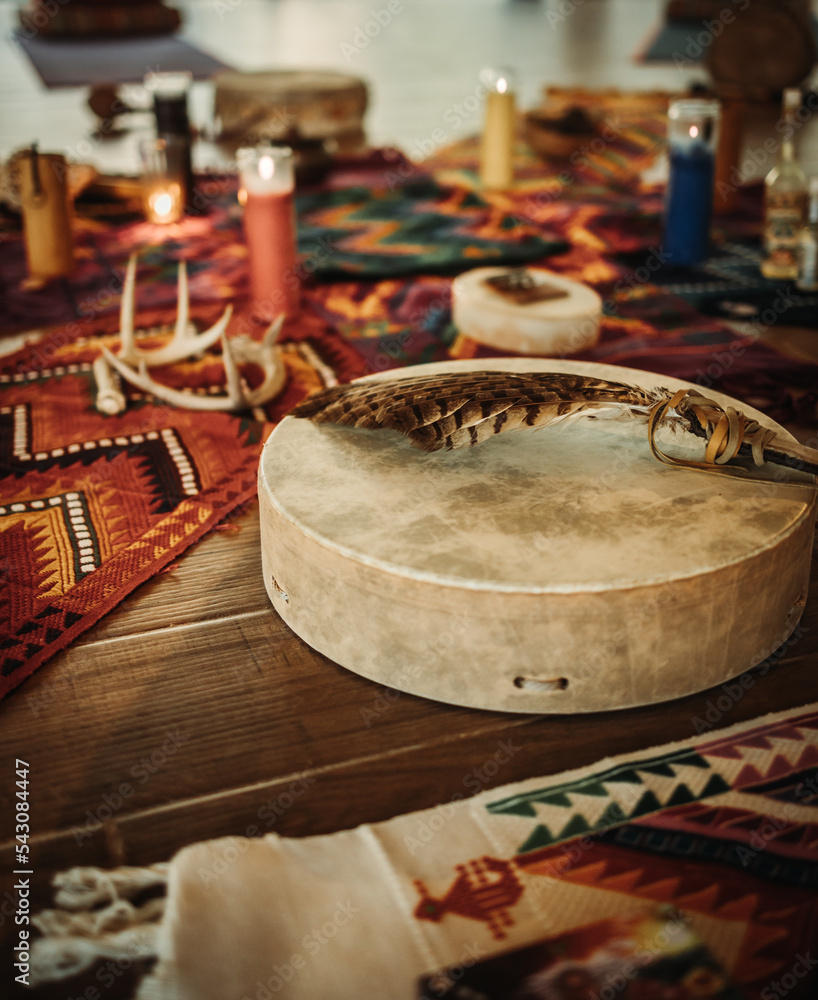 Leather percussion instrument with feather on top and red carpet with ...