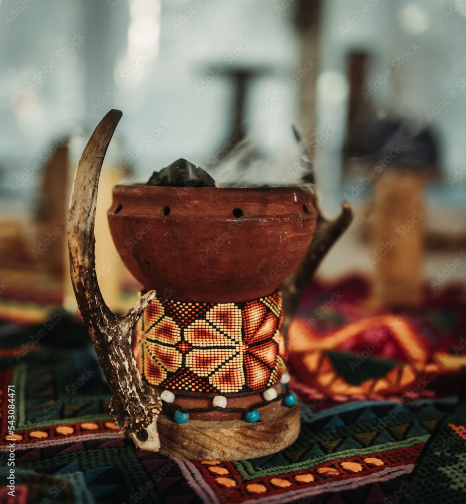 Incense burner with horn on a colorful blanket with indigenous pattern ...