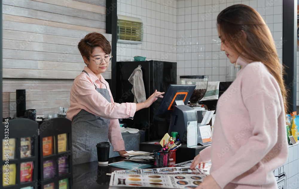 cashier staff receive customer orders from a waitress at counter in ...
