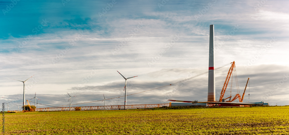 Building and assembling a construction windturbine by crane. Farmland ...