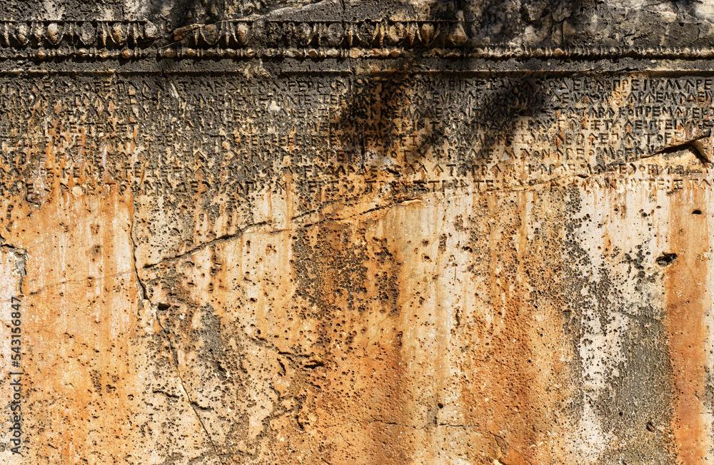 Ancient Greek antique text and inscriptions on the stone wall of the ...
