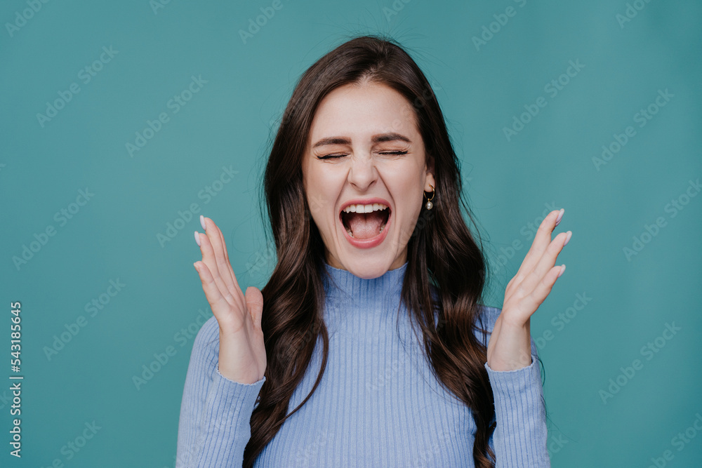 Loud screaming brunette angry girl in lilac sweater eyes closed with ...