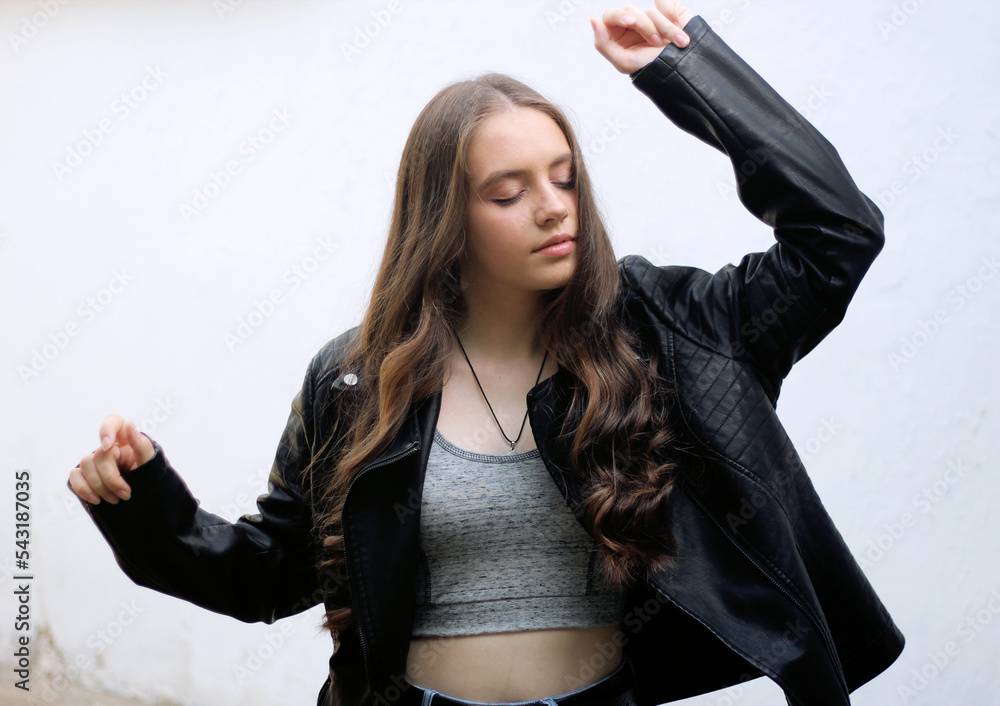 a dark-haired young girl in a black leather jacket is dancing Stock ...