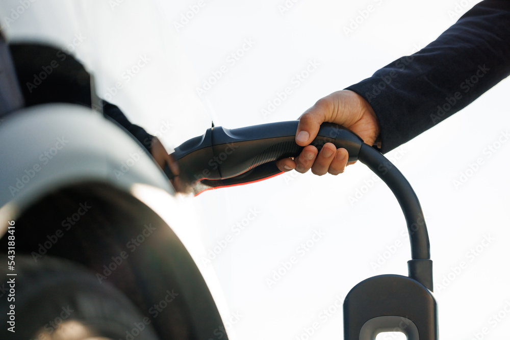 Close up of charging cable connecting to the electric vehicle for ...