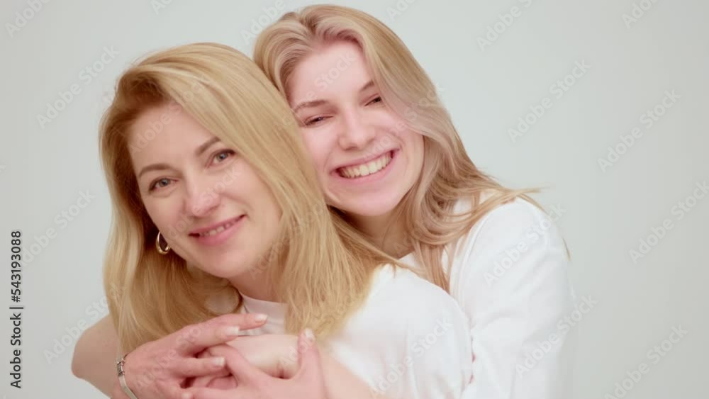 Portraits of blondes mother and daughter, studio shot, white background ...