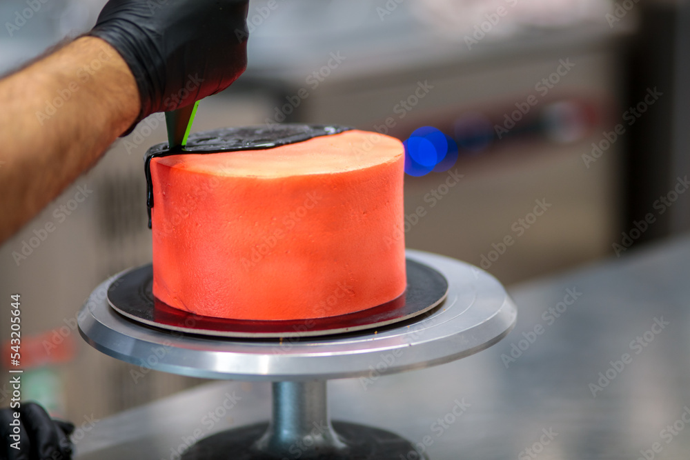 pastry chef decorating airbrush painted cup frosted icing cake with ...