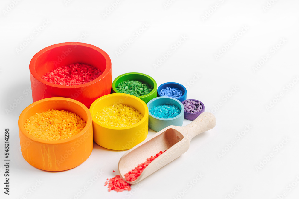 Bowls in rainbow colors with colored rice and scoops. Sensory bin ...