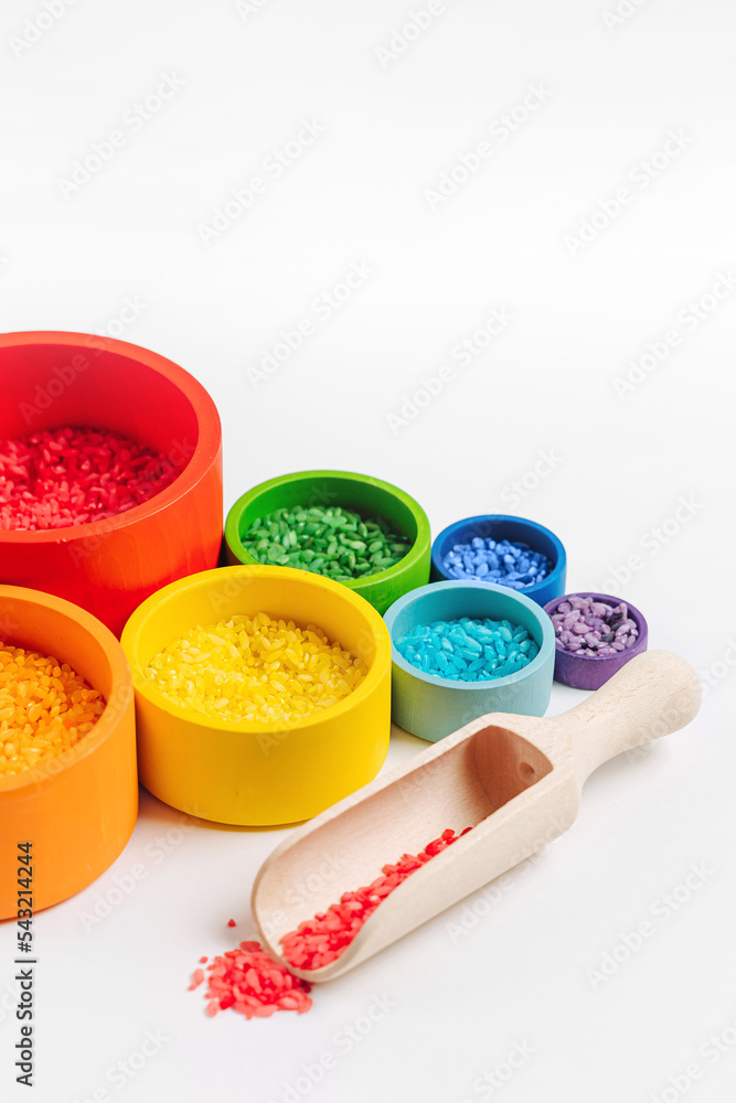 Bowls in rainbow colors with colored rice and scoops. Sensory bin ...