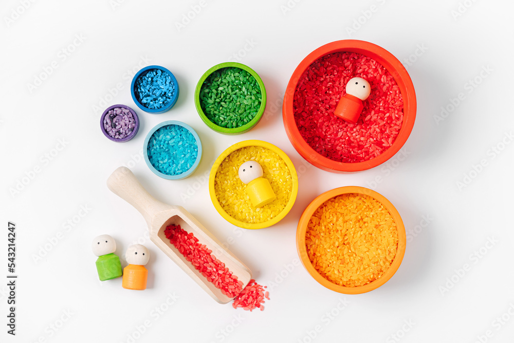Bowls in rainbow colors with colored rice and scoops. Sensory bin ...
