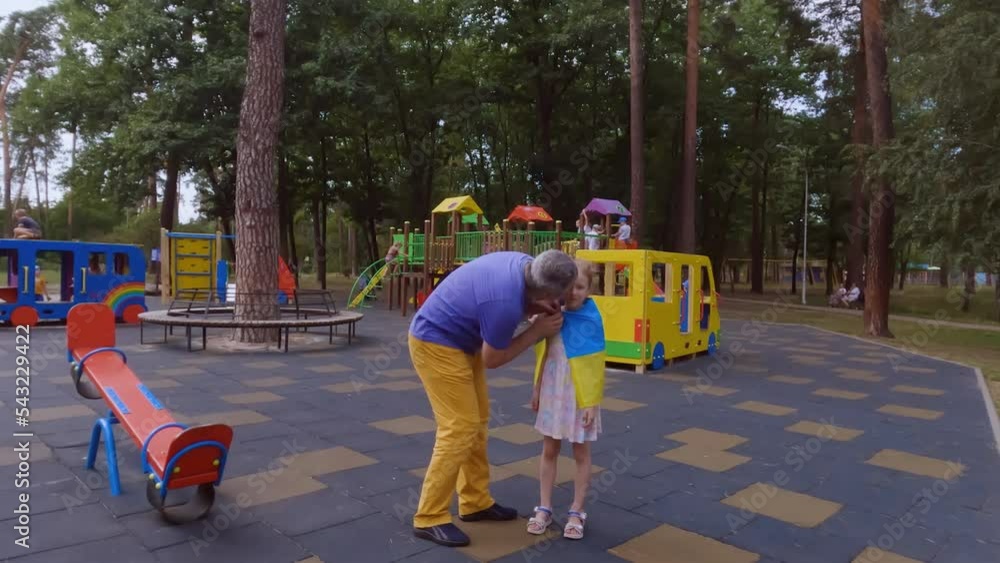 Ukrainian father tying the Ukrainian flag to his daughter. He teaches ...