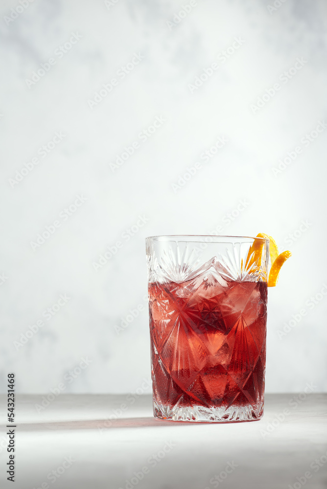 Negroni cocktail in a rocks glass with orange peel on a white ...