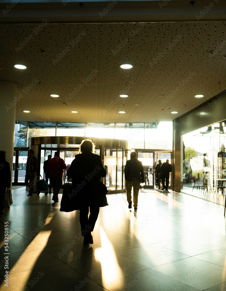 people going in and out of the mall with the sun shining Stock Photo ...