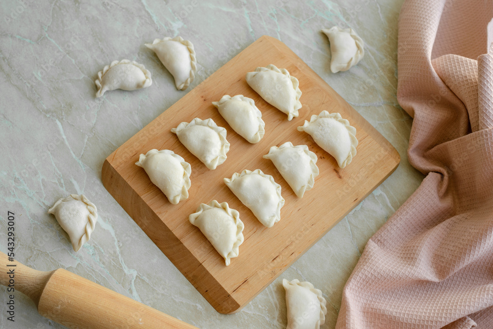Beautiful raw stuffed dumplings on a wooden cutting board Stock Photo ...