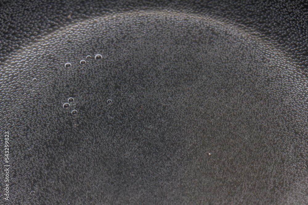 little bubbles in the boiling water inside the pan. details of the hot ...