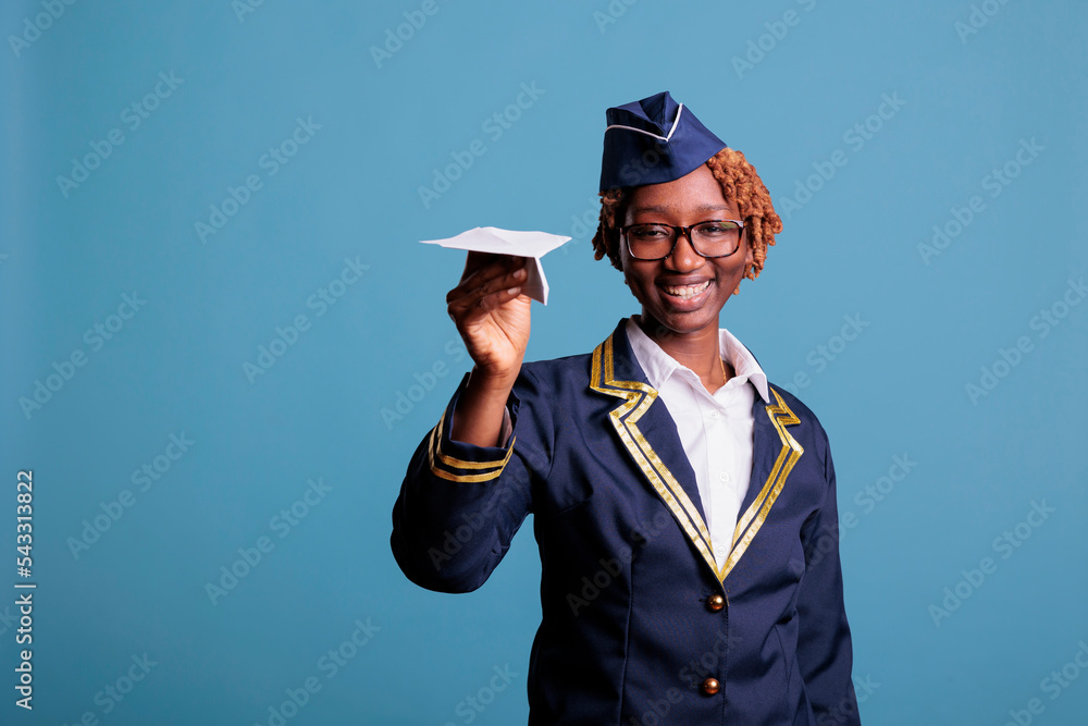 Flight attendant in professional uniform launching paper airplane in ...