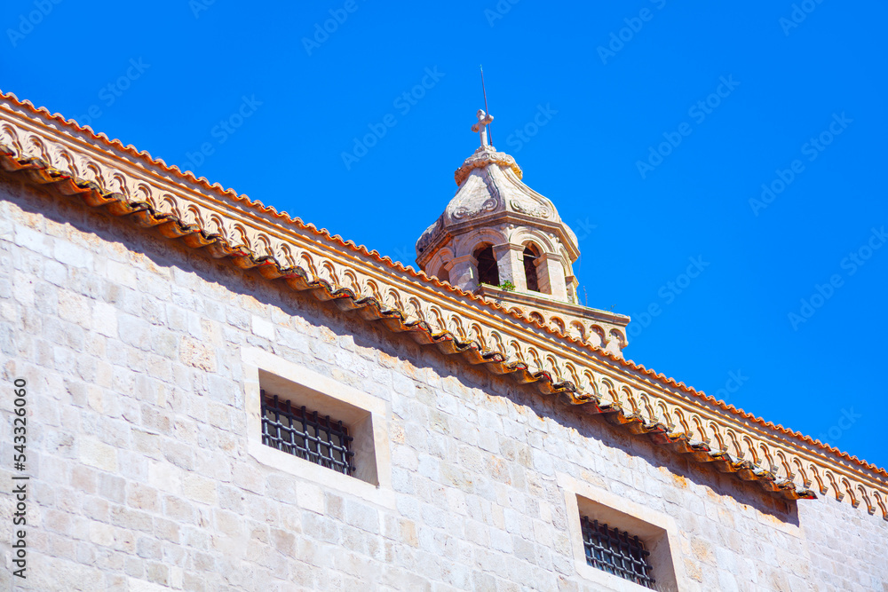 Turret and tiles of the old fort . White wall and windows with grates ...