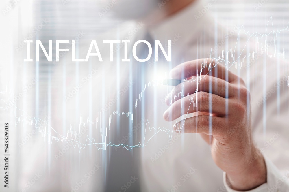 businessman writes word inflation against background of graph chart of ...