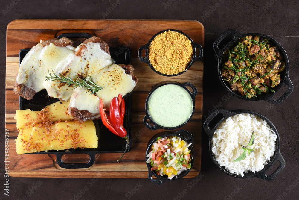barbecued meat with cassava fried banana rice beans and herb sauce ...