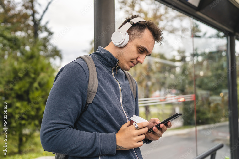 One man young adult male stand at public transport bus station waiting ...
