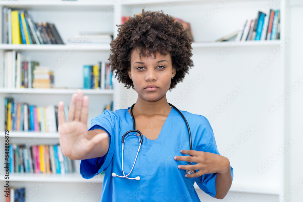 Afro american female nurse gesturing stop and social distancing Stock ...