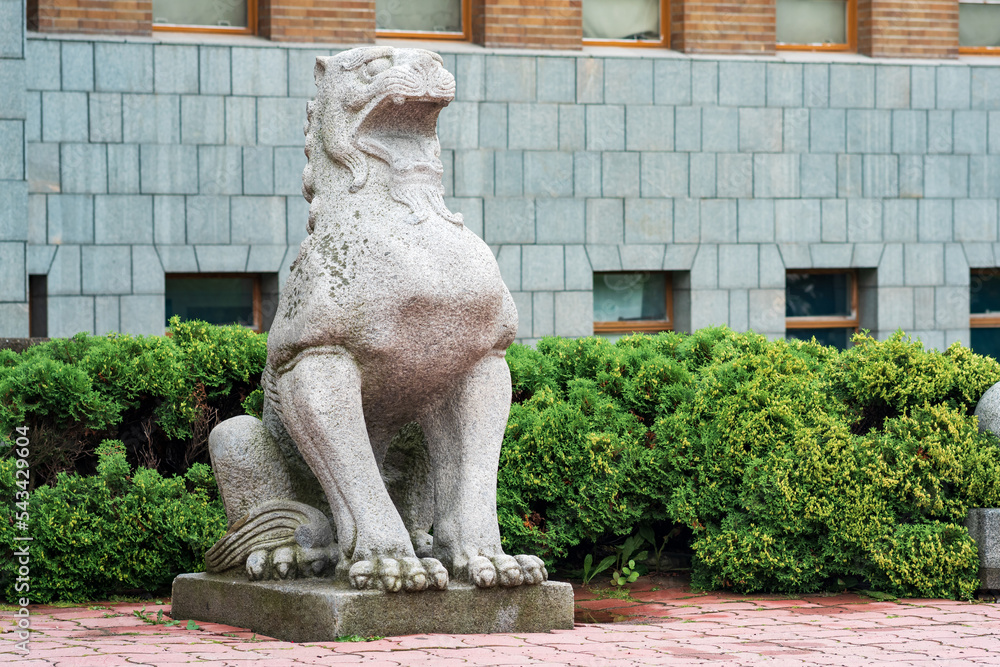traditional Japanese statue of a stone lion at the entrance to the ...