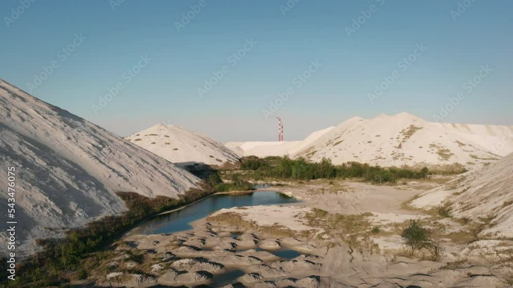 An aerial view of a chemical desert with large mountains of waste. A ...