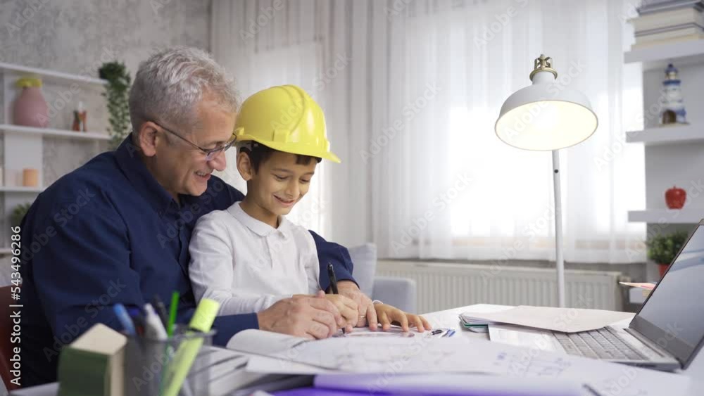 Engineer father works at home with his son. The son, who wears his ...