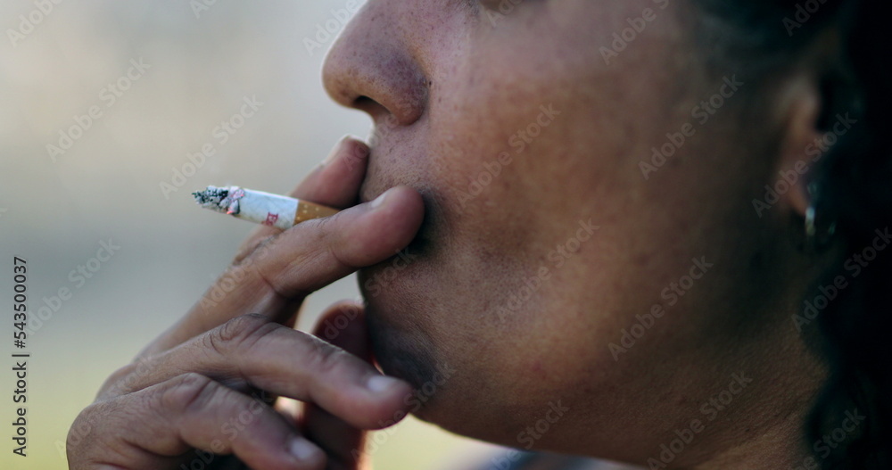 Stressed mature woman smoking cigarette. Anxious person biting lip ...