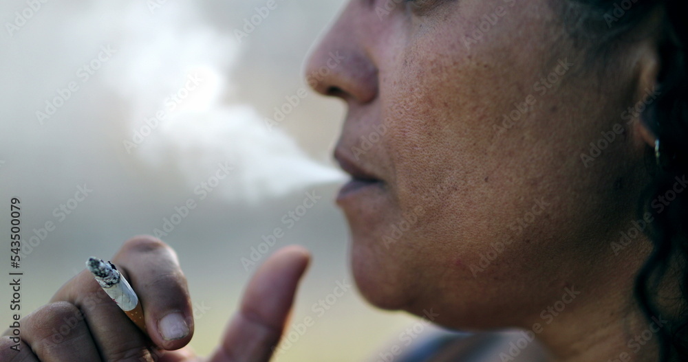 Stressed mature woman smoking cigarette. Anxious person biting lip ...