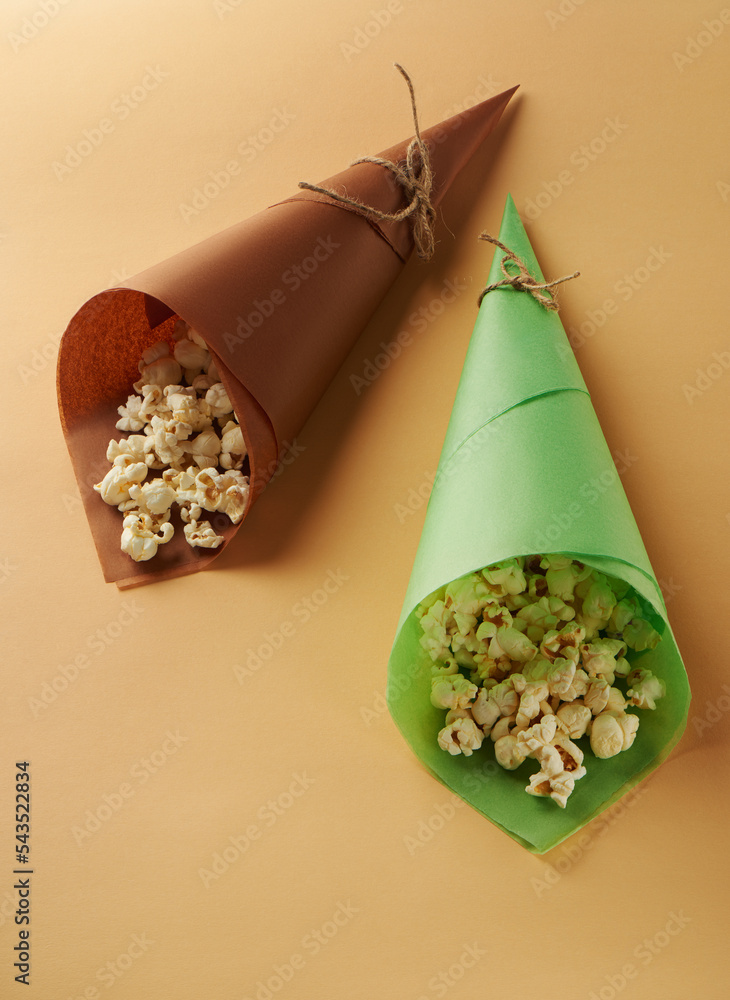 Brown and green paper cones with popcorn on yellow background Stock ...