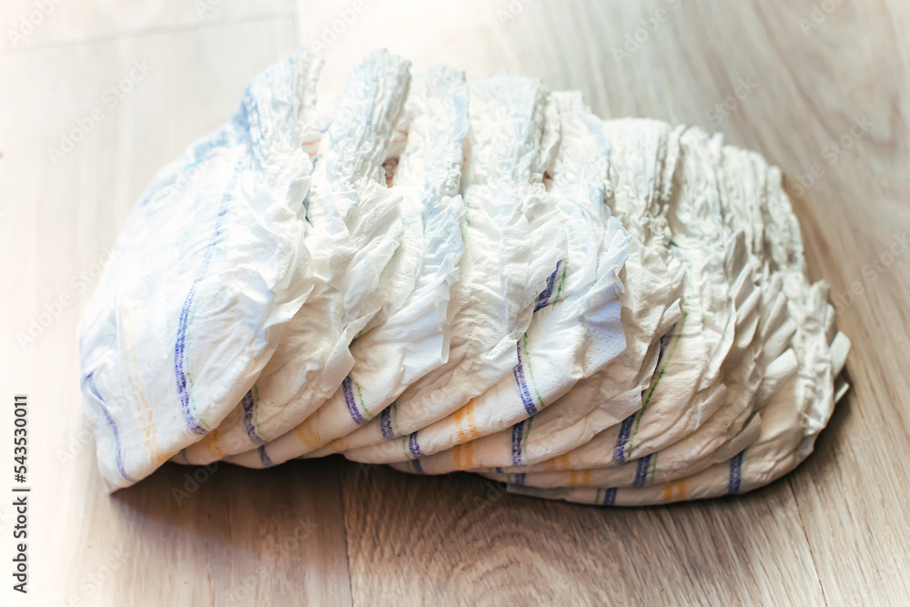 Scattered on the floor are a bunch of clean diapers. Personal hygiene ...