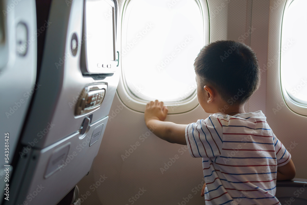 Asian children look at the aerial view of the sky and clouds outside ...