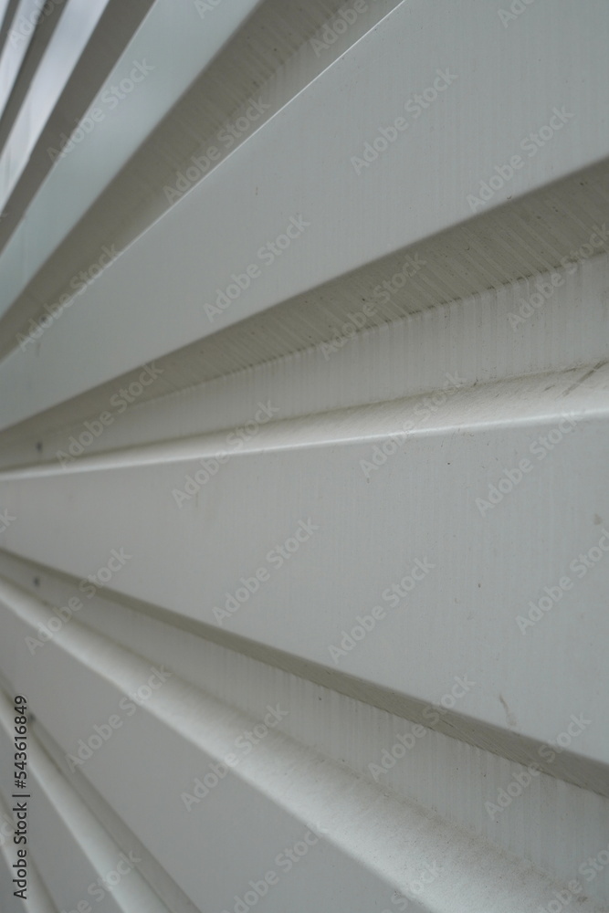 PVC white grooved wall fencing construction site. Converging grooves ...