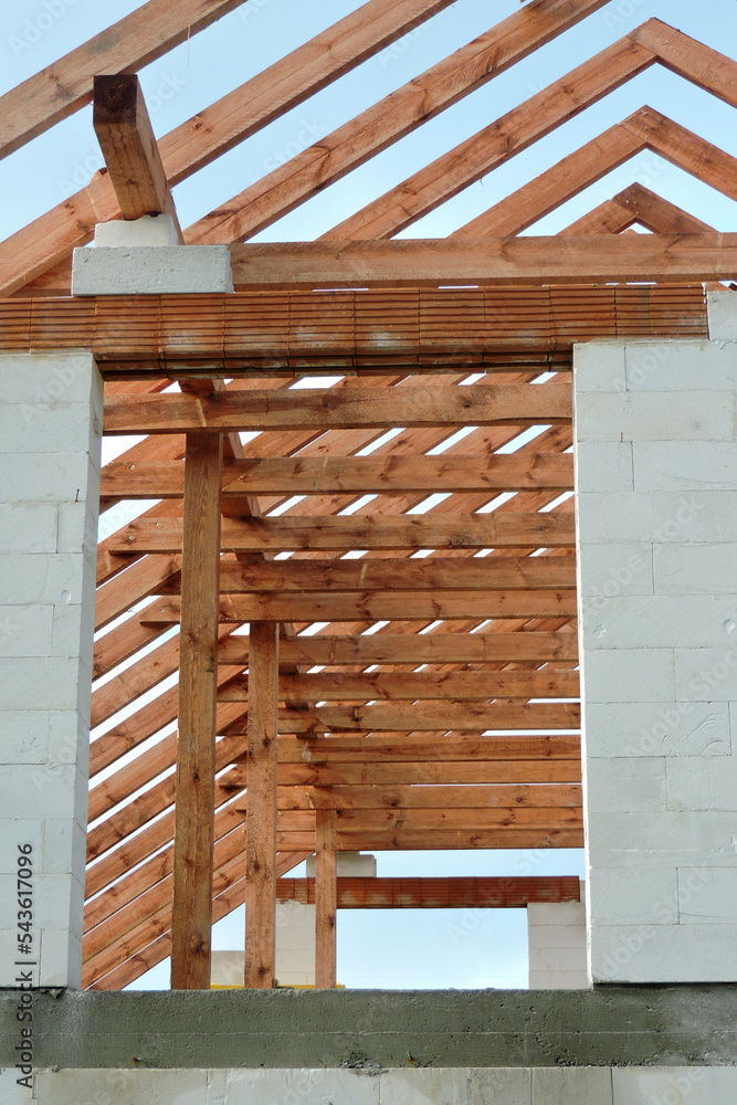 A timber roof truss in a house under construction, walls made of ...