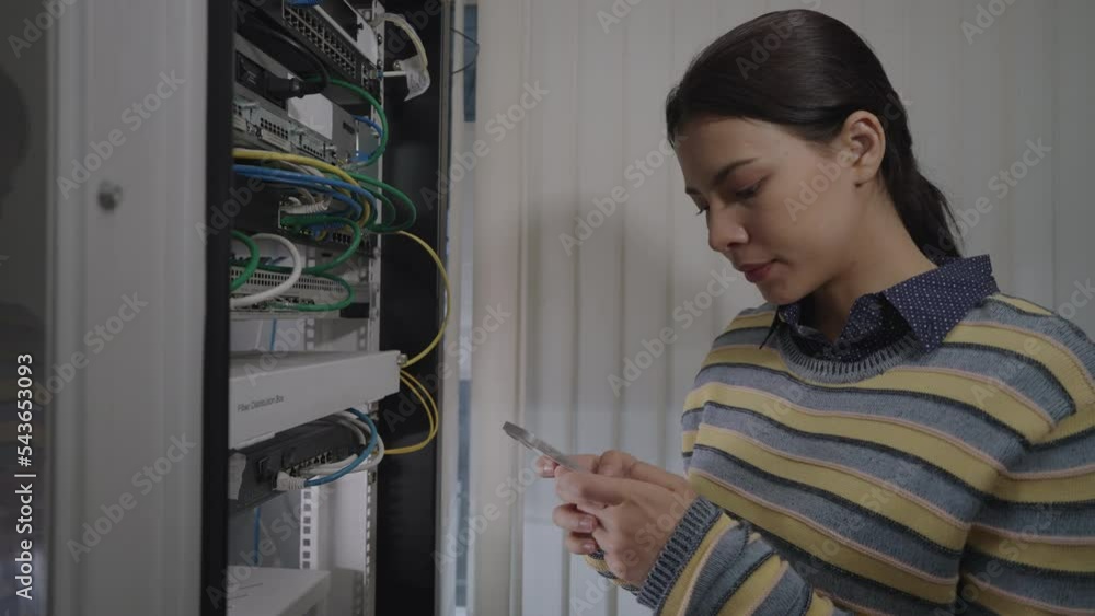 Server room, Beautiful woman checks the network of fiber optic cables ...