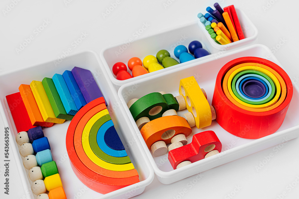 Colorful wooden toys in the colors of the rainbow in plastic box ...