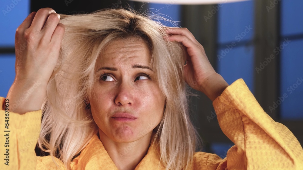 Damaged hair. Sad young woman with tousled hair. Close-up portrait of a ...