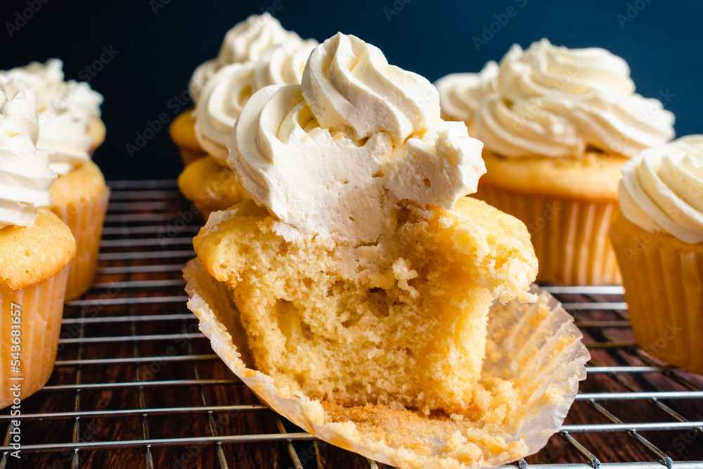 Vanilla Cupcake with Buttercream Frosting and Filling with a Bite Taken ...